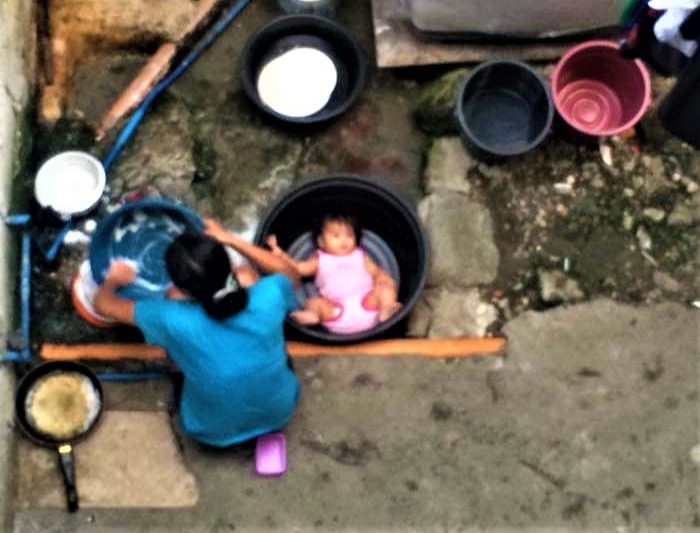 Pinay mom places child in a tub as she washes dishes | The Filipino Times